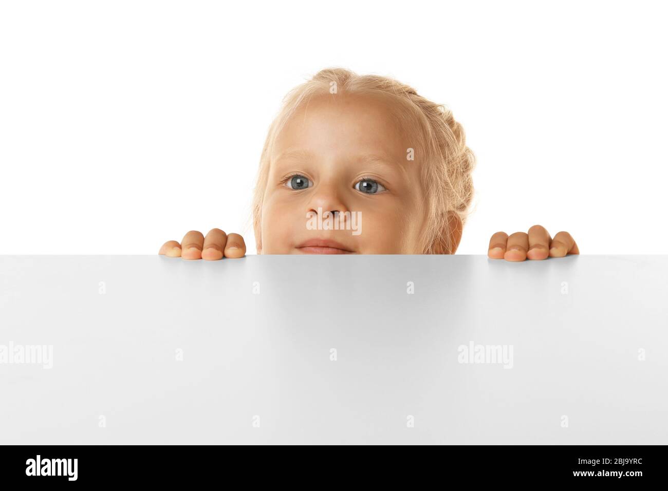 Funny little girl hiding behind white table Stock Photo - Alamy