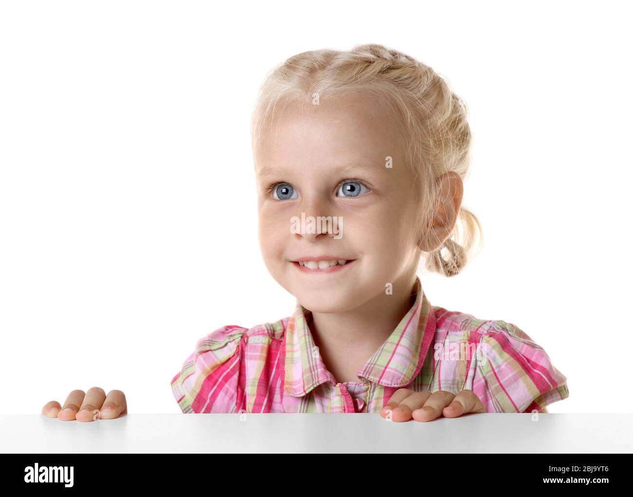 Funny little girl hiding behind white table Stock Photo - Alamy