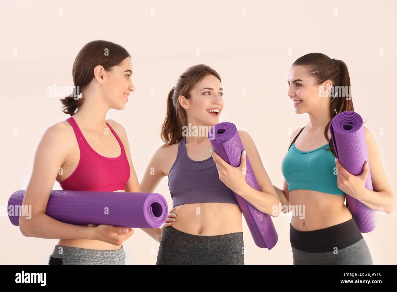 Young women with mats in gym Stock Photo - Alamy