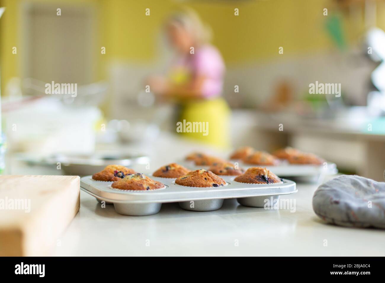 Confectioner took out freshly baked muffins in a baking dish on the ...