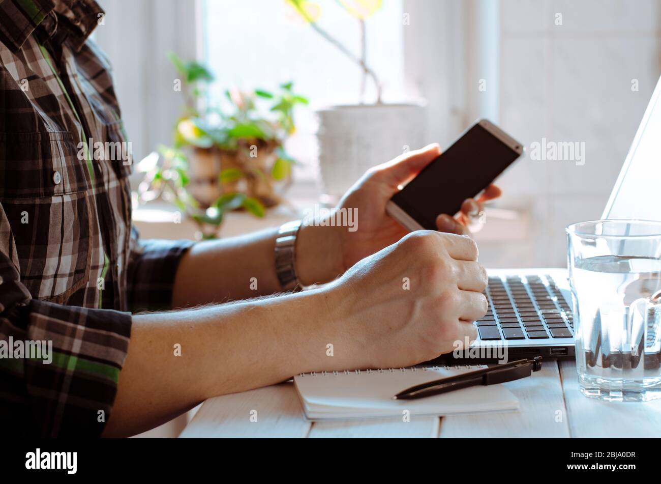 Freelancer works in the home office sitting at the desk near the window ...