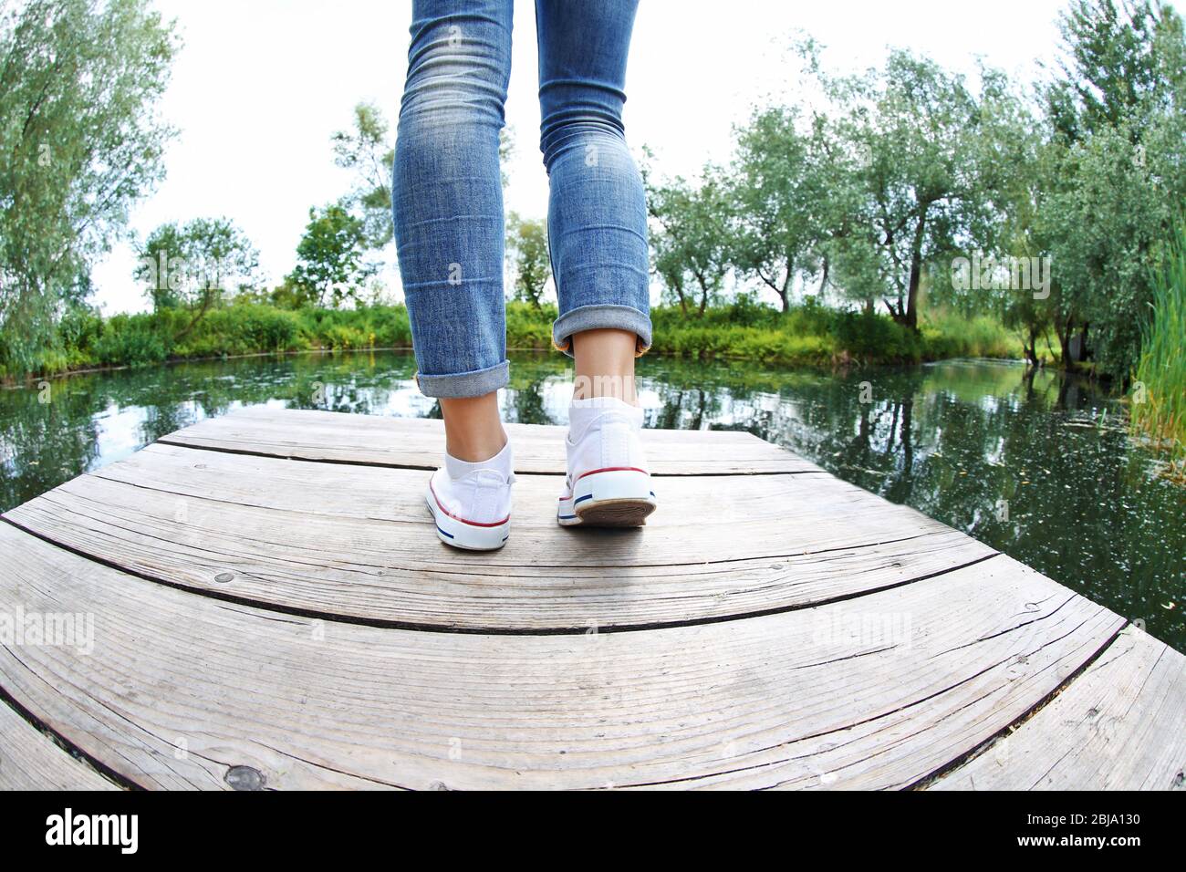 Woman legs on wooden pier. Beautiful landscape Stock Photo - Alamy