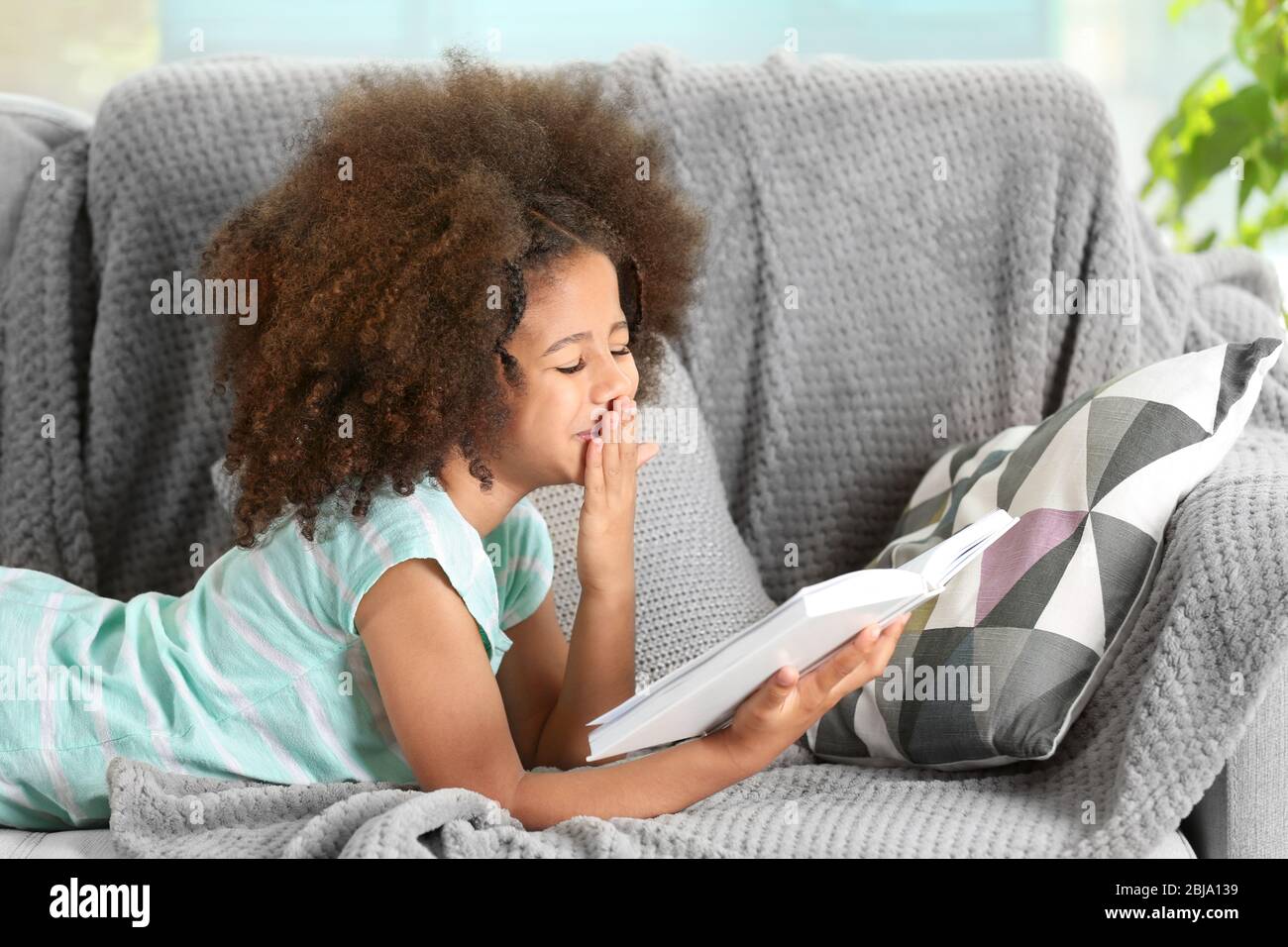 Cute african girl reading hi-res stock photography and images - Alamy
