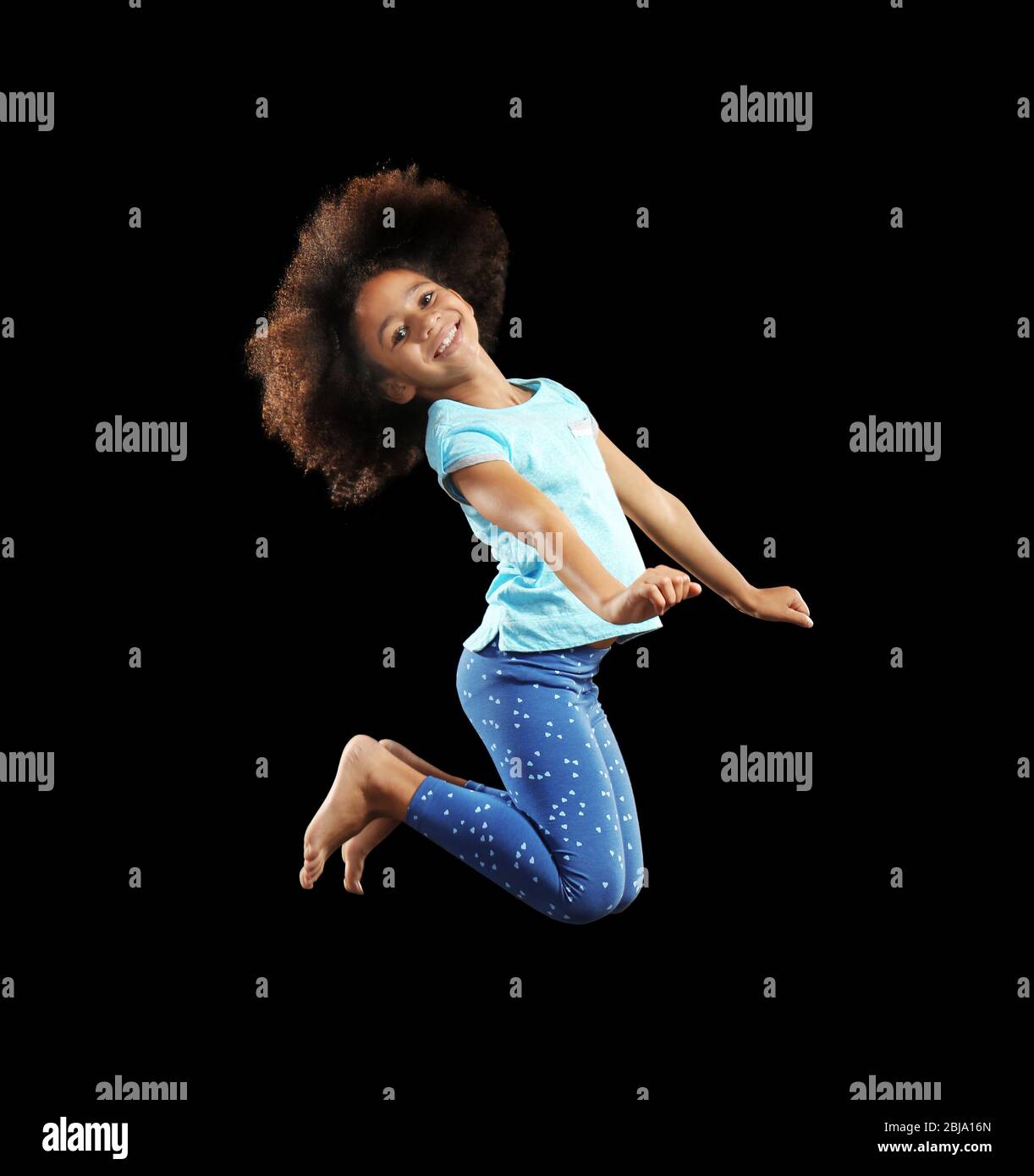 Happy African girl jumping on black background Stock Photo - Alamy