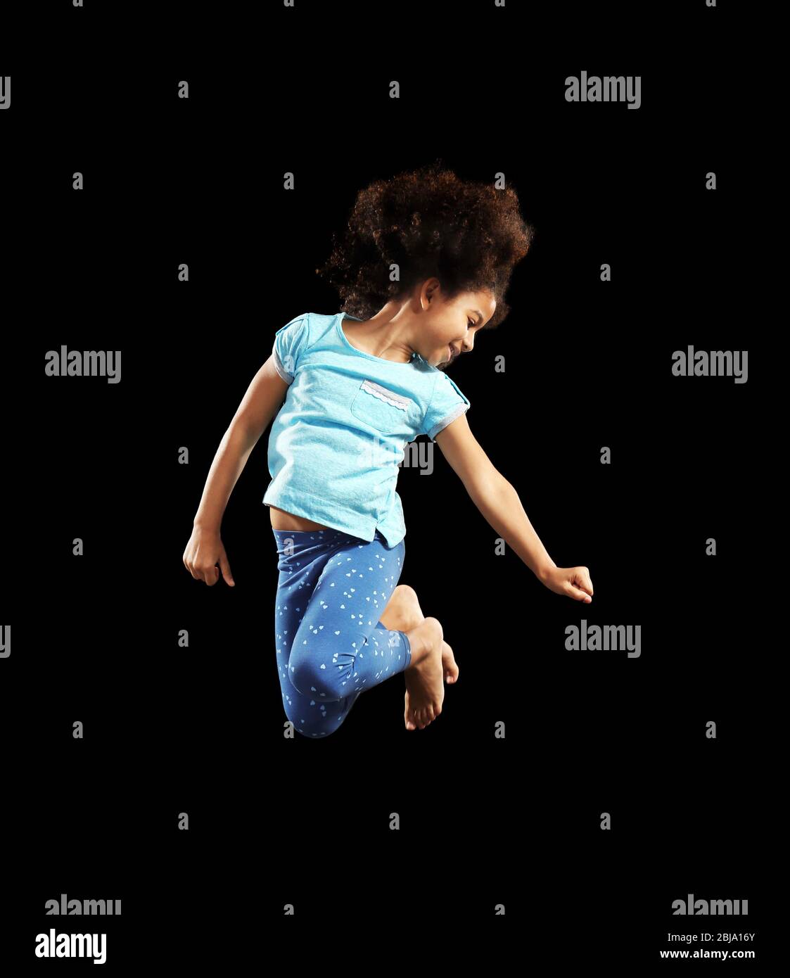 Happy African girl jumping on black background Stock Photo - Alamy