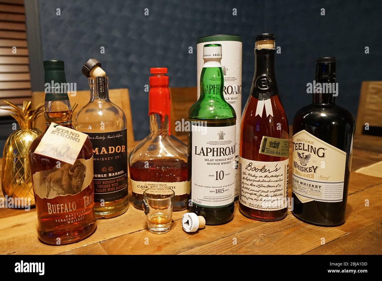 Bottles of famous whiskey arranged on wooden table bar Stock Photo - Alamy