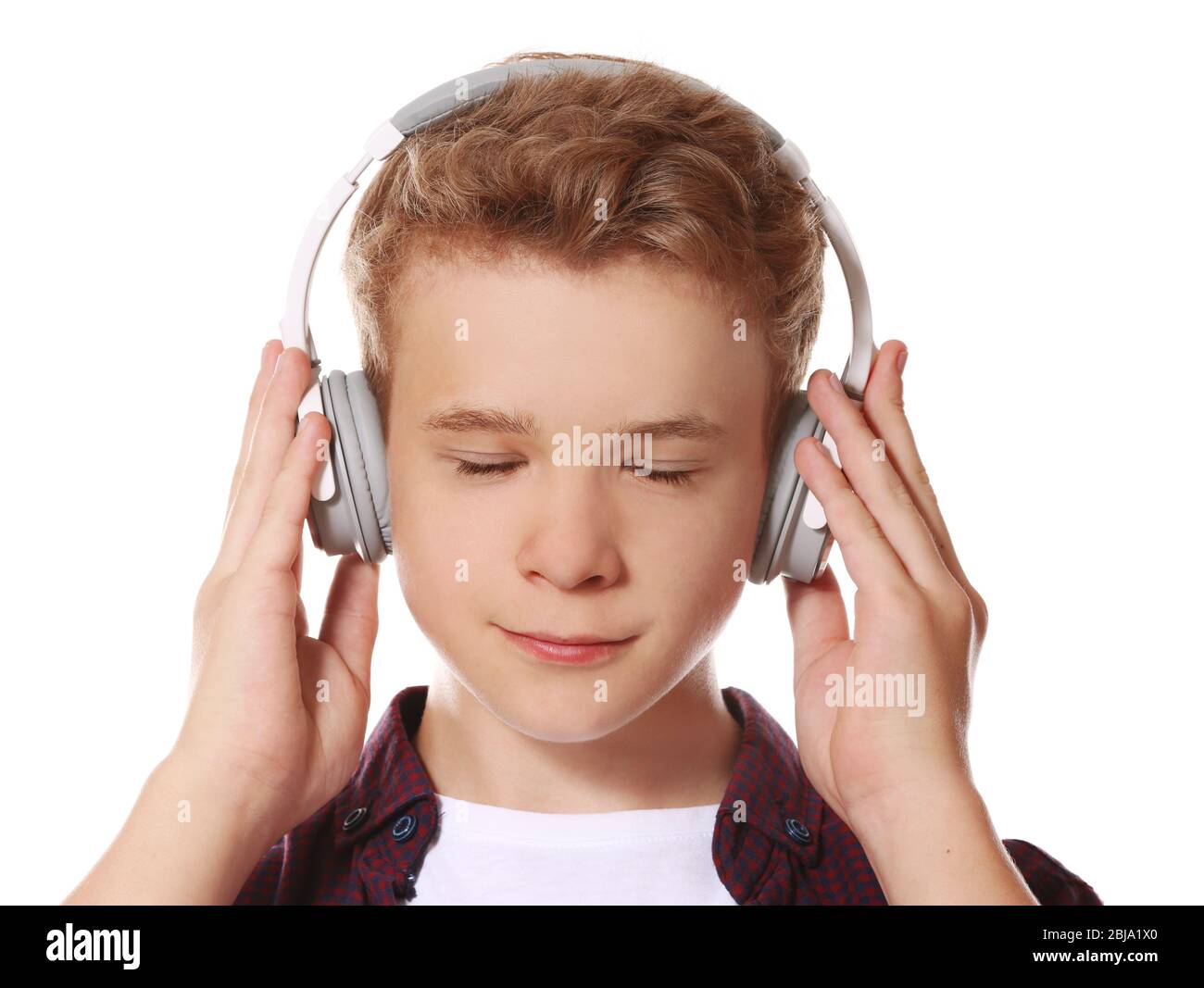 Boy listening music on light background Stock Photo - Alamy