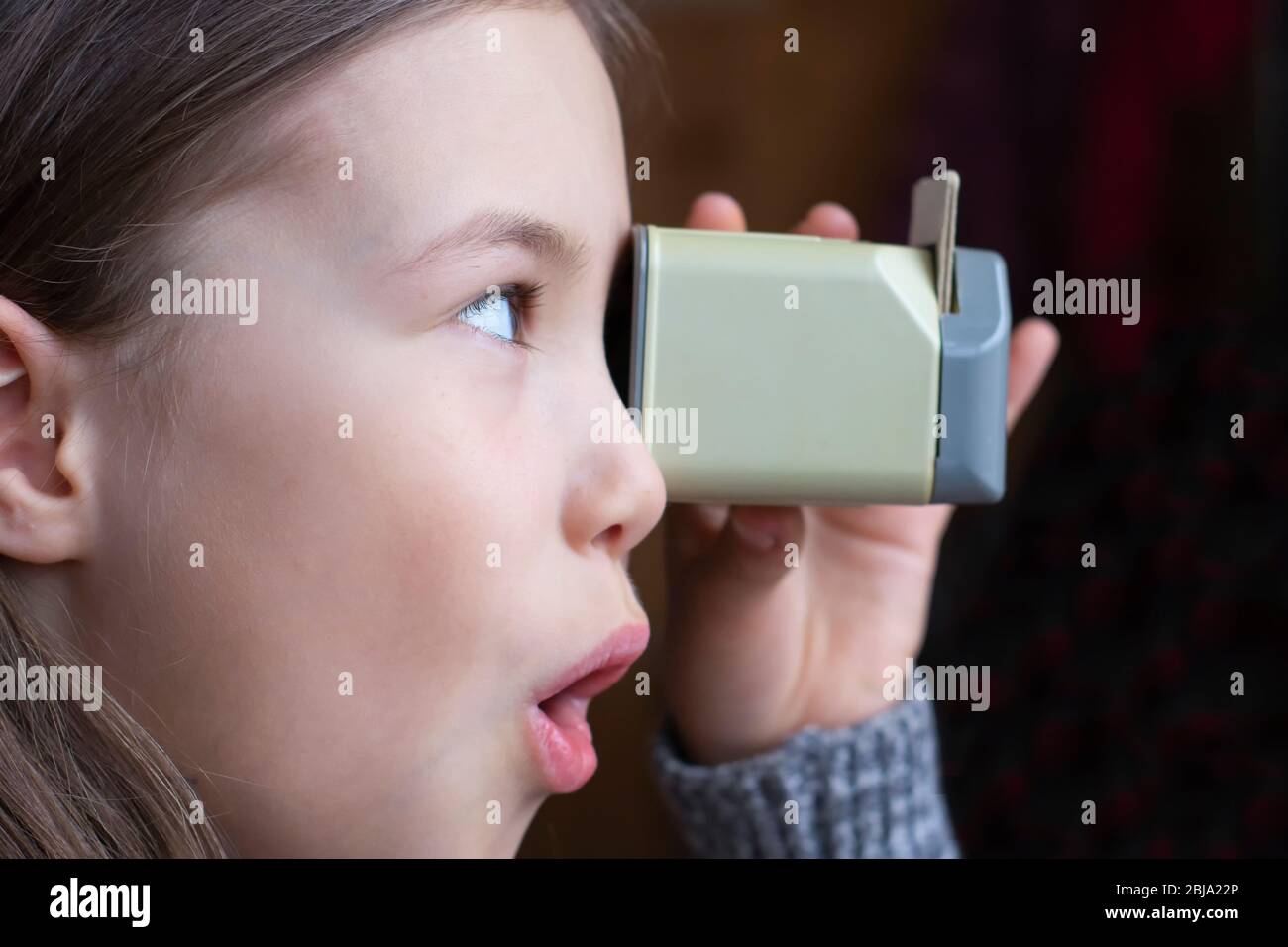 Child girl looks at old photos through a diascope Stock Photo - Alamy