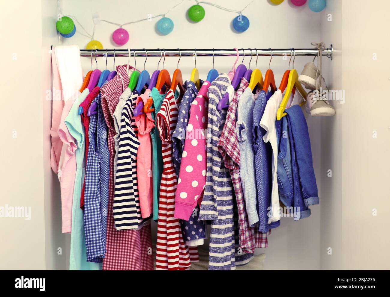 Children clothes hanging on hangers in the wardrobe Stock Photo - Alamy