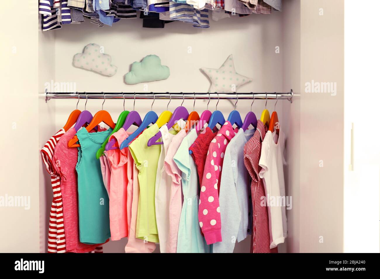 Children clothes hanging on hangers in the wardrobe Stock Photo - Alamy