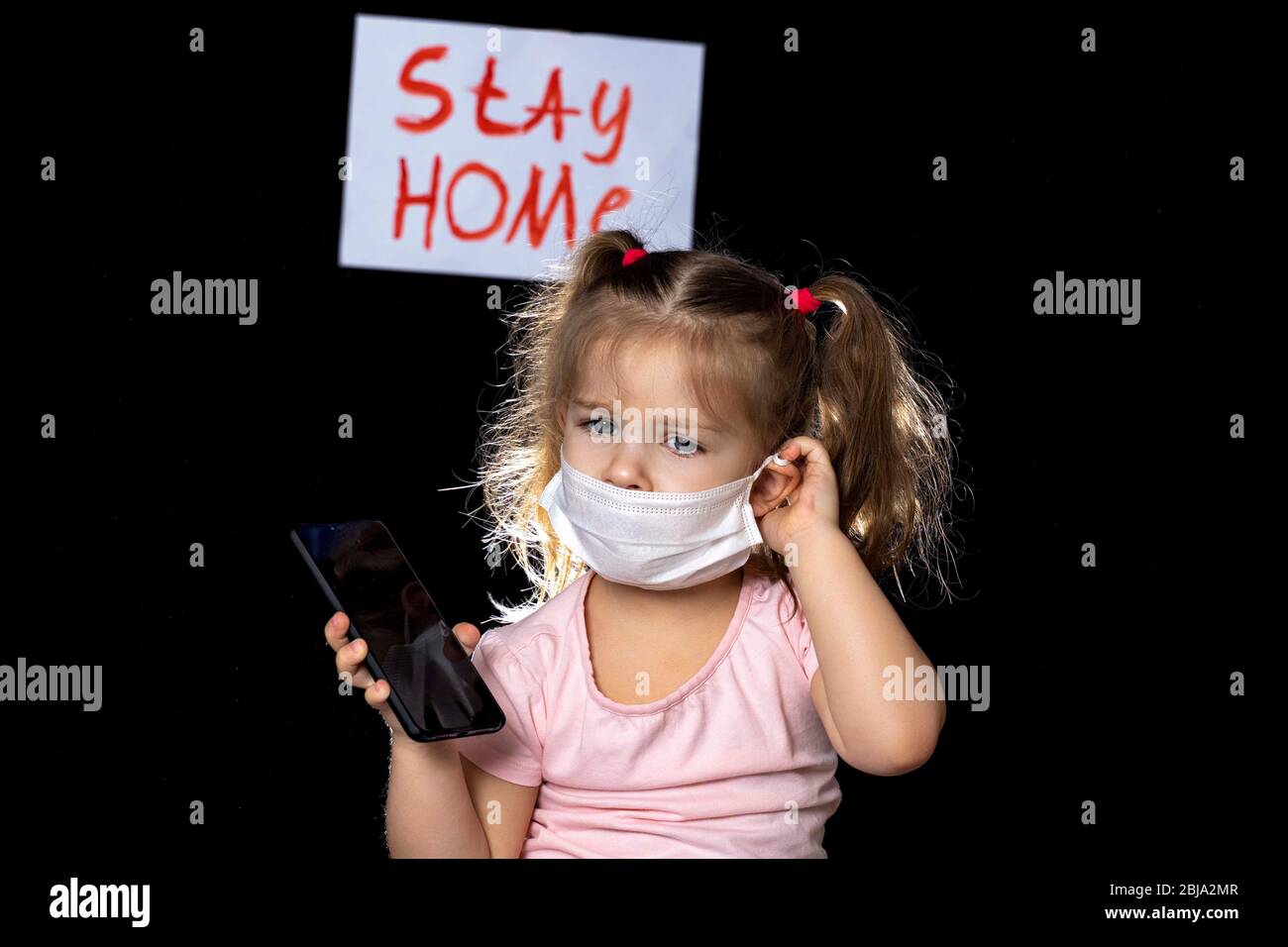 little girl talking on the phone on a black background and talking on a ...