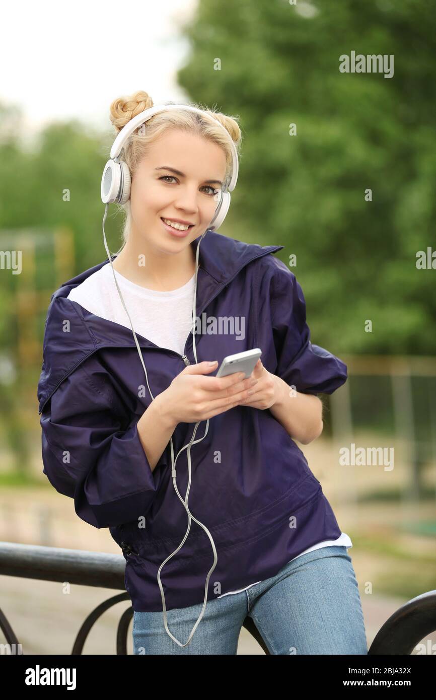 Beautiful girl listening music on street Stock Photo - Alamy