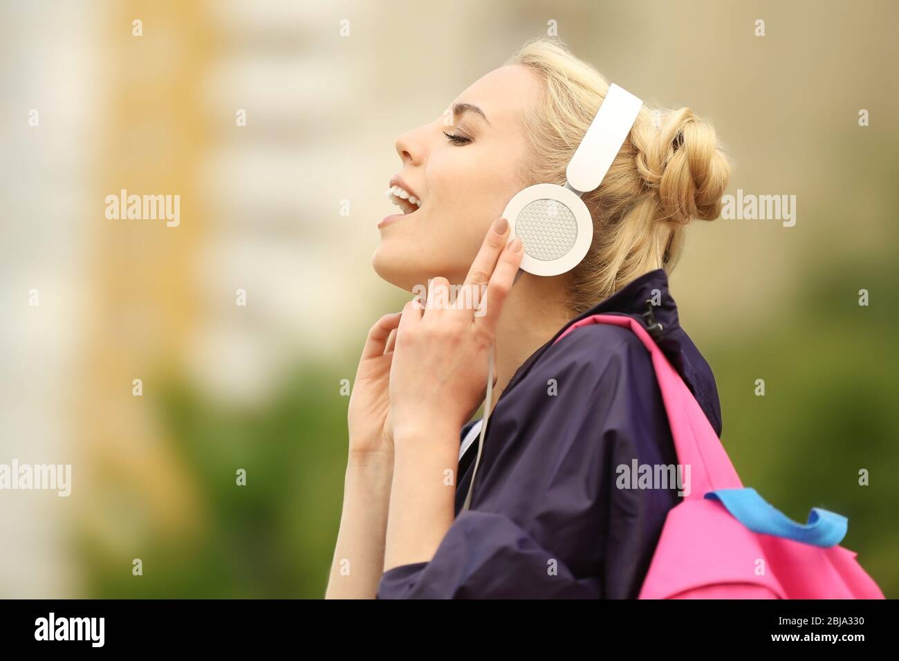 Beautiful girl listening music on street Stock Photo - Alamy