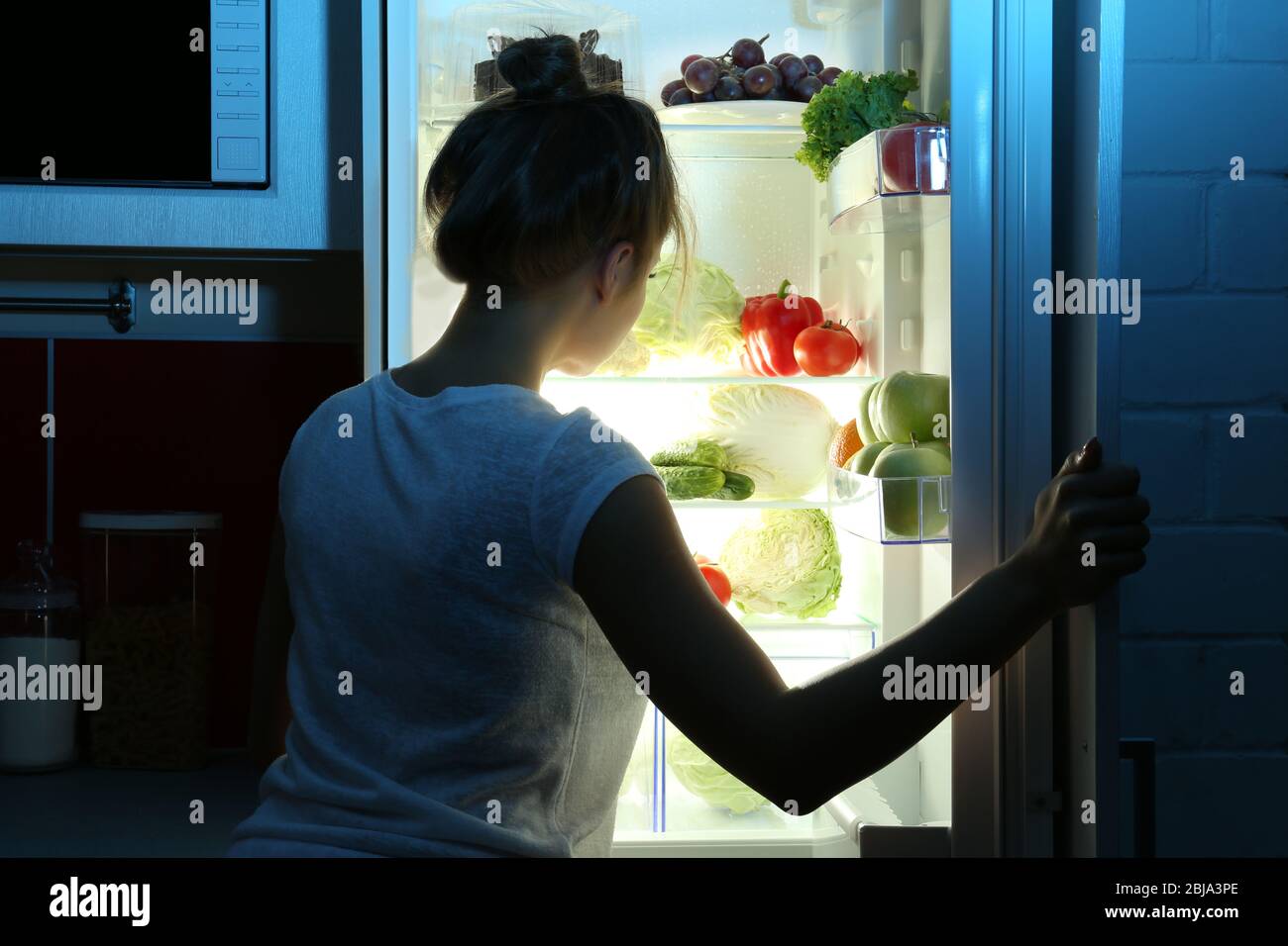 Beautiful girl searching for food in fridge. Hunger concept Stock Photo ...