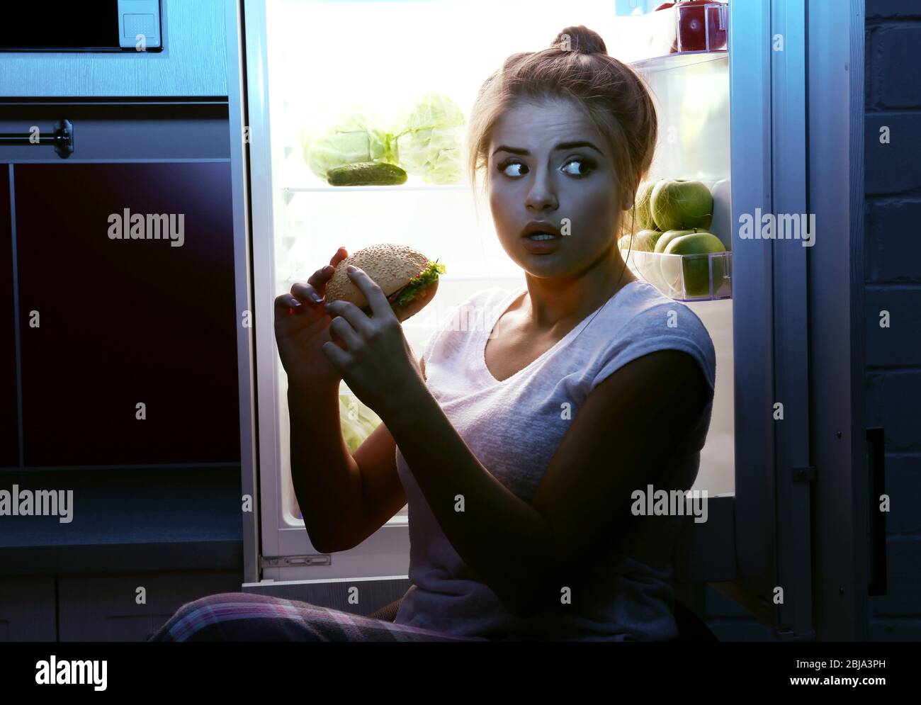 Beautiful girl eating sandwich at night. Unhealthy food concept Stock ...