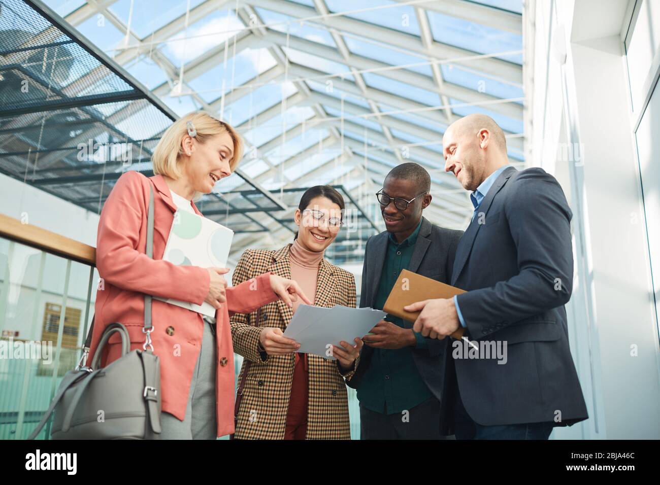 Group of business people discussing documents together before meeting ...