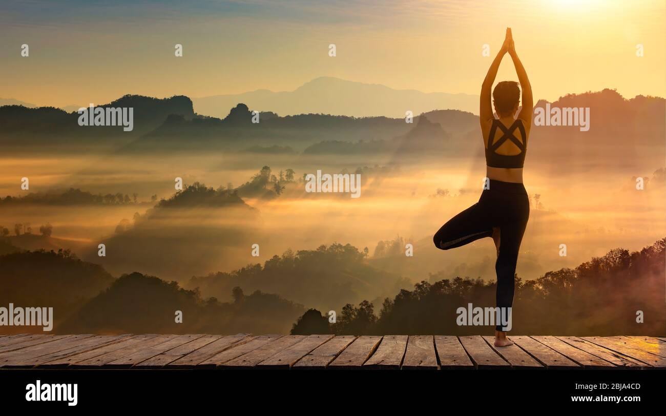 Young girl doing yoga fitness exercise outdoor in beautiful mountains ...