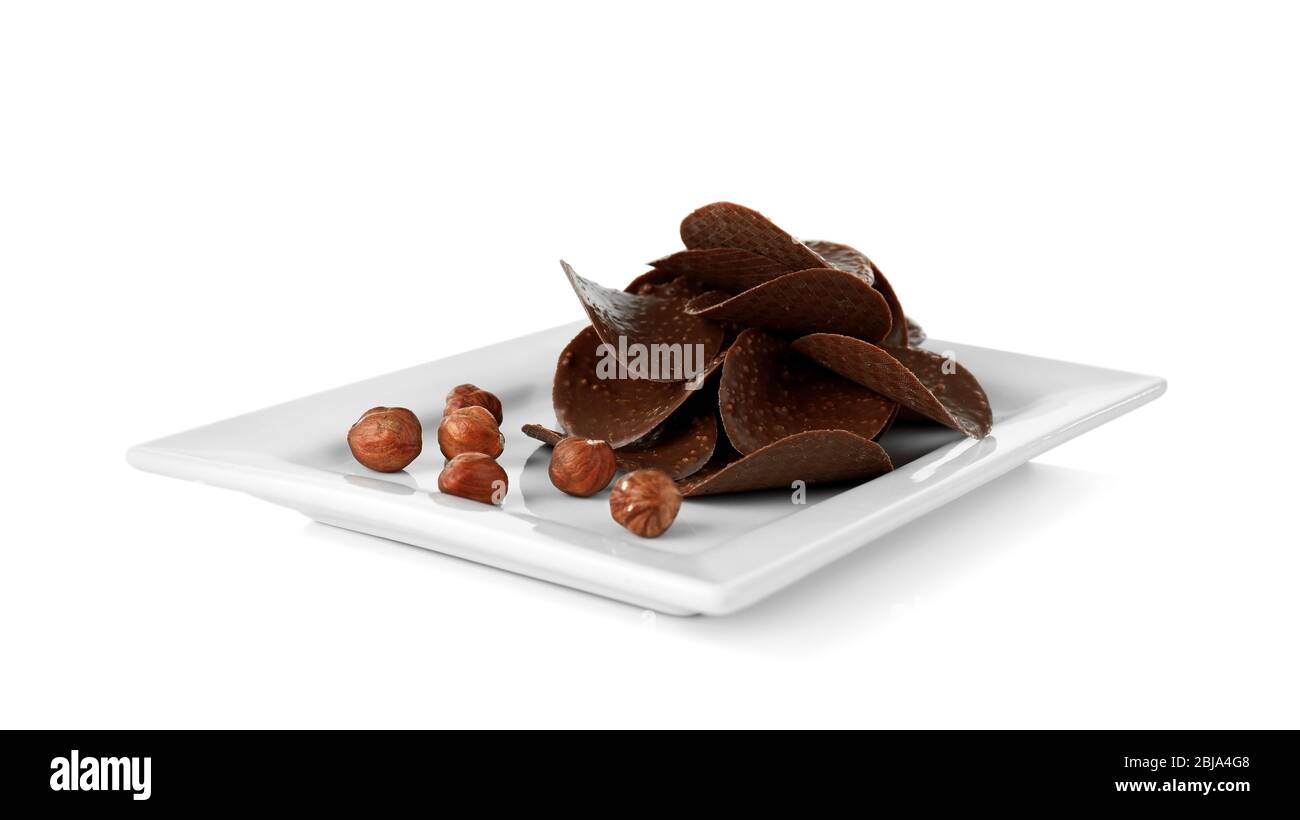Chocolate chips and hazelnuts in plate on white background Stock Photo ...
