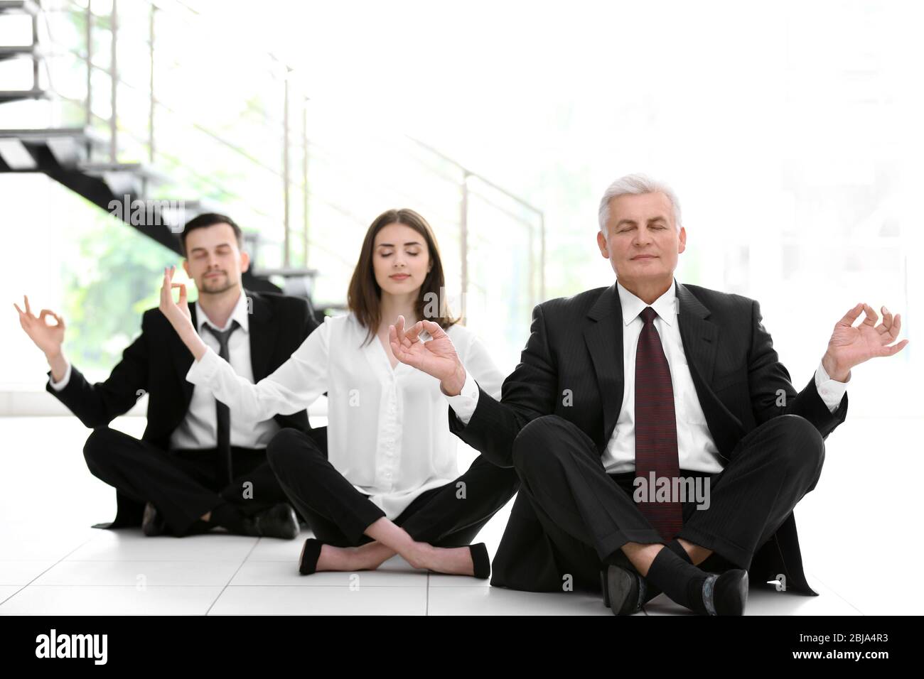 Business people relaxing in meditation pose in office Stock Photo - Alamy