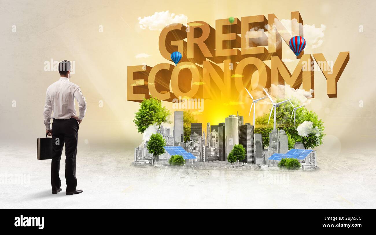 Rear view of a businessman standing in front of GREEN ECONOMY ...