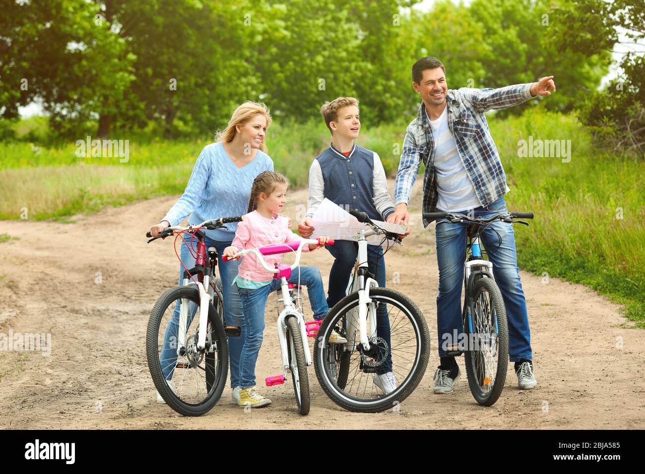 Happy family with map on bike ride Stock Photo - Alamy