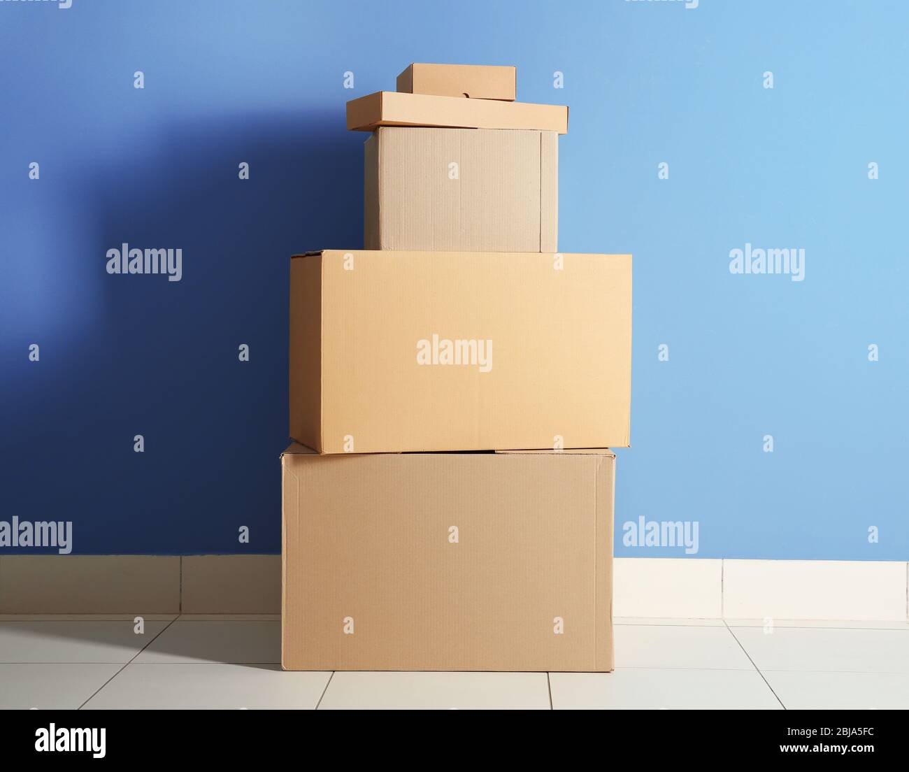 House move concept. Carton boxes on blue wall background Stock Photo ...