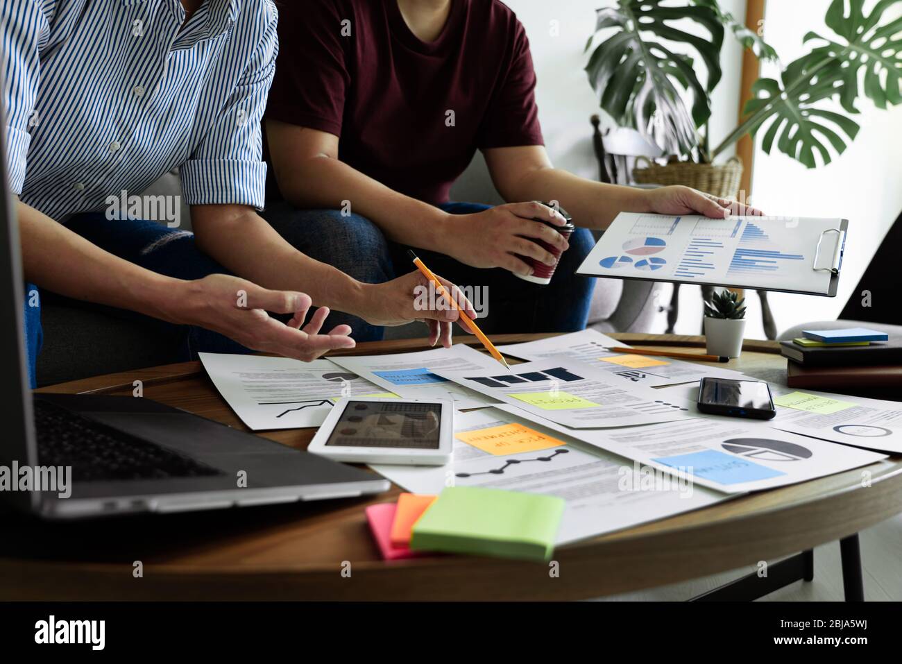 Business people writing on sticky notes for colleagues thinking ...