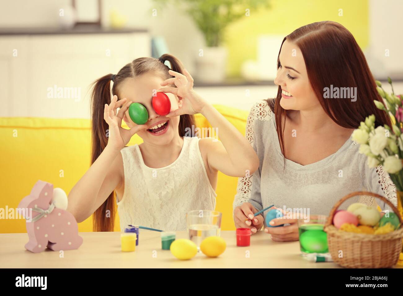 Mother and daughter with Easter eggs having fun at home Stock Photo - Alamy