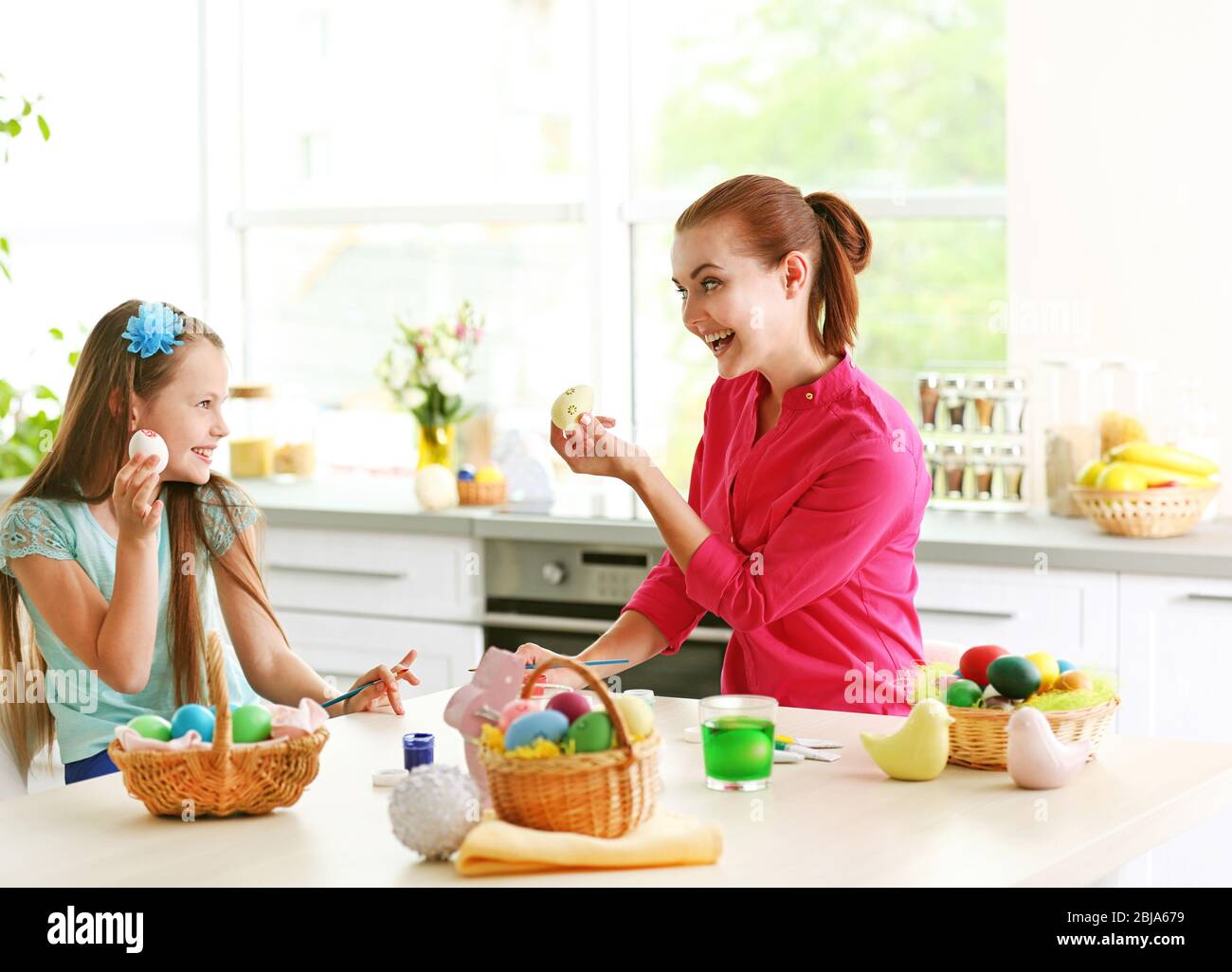 Mother and daughter painting eggs at Easter eve Stock Photo - Alamy