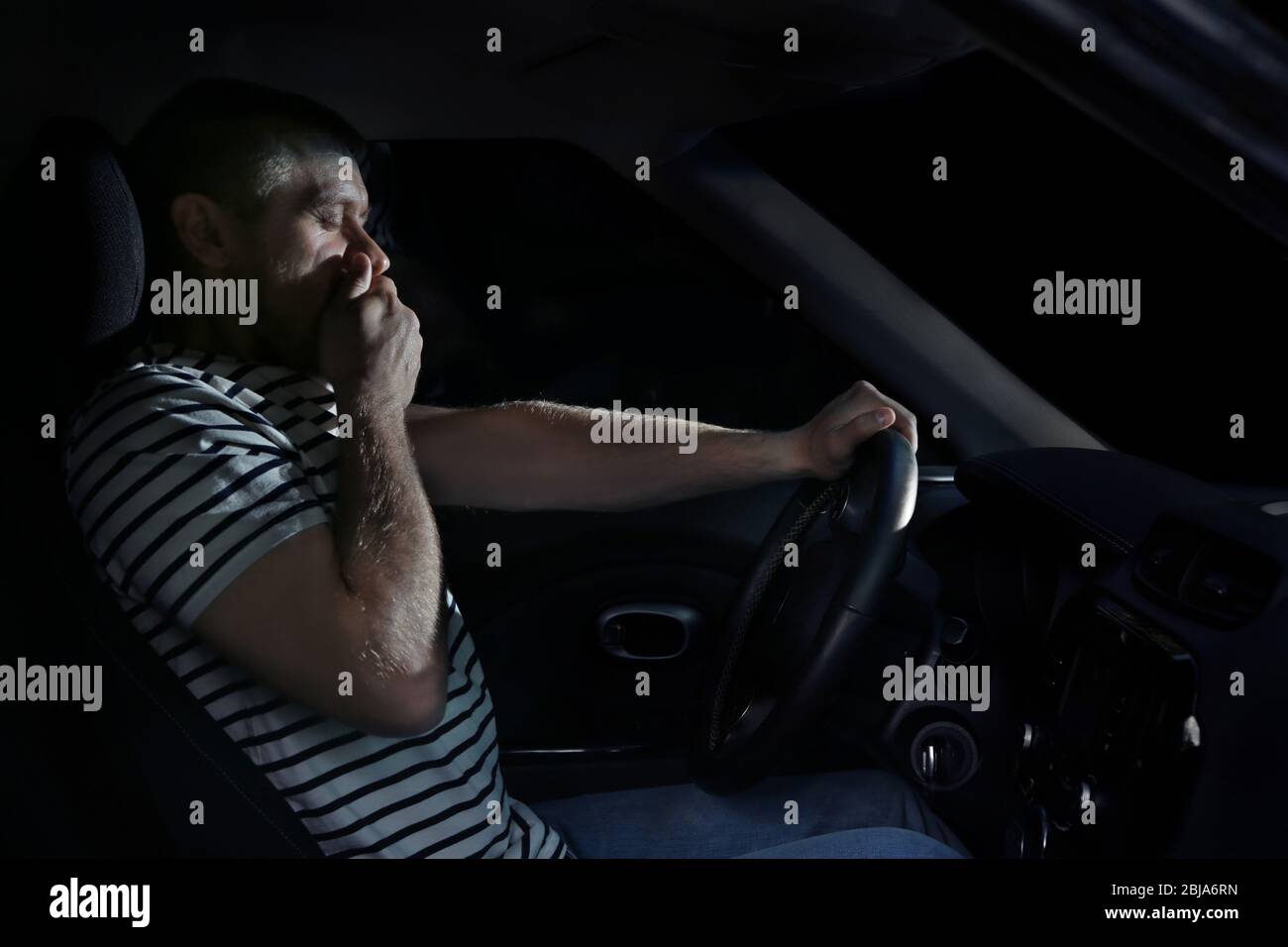 Tired handsome man falling asleep in car Stock Photo - Alamy
