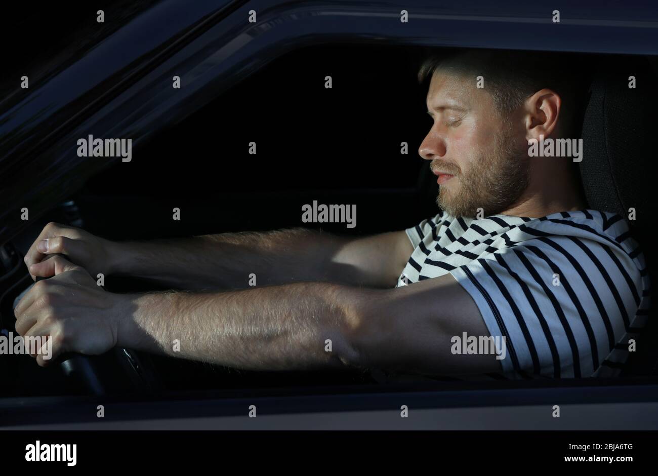 Tired handsome man falling asleep in car Stock Photo - Alamy