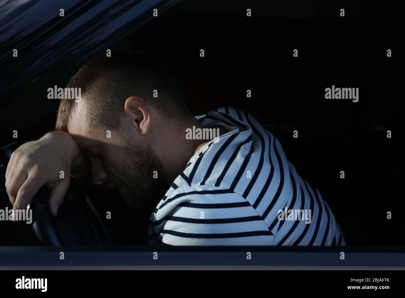 Tired handsome man falling asleep in car Stock Photo - Alamy