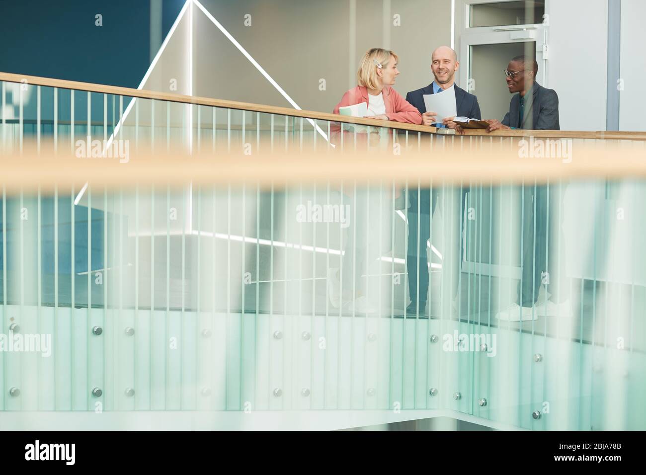 Business partners standing with papers and notebook and planning work ...