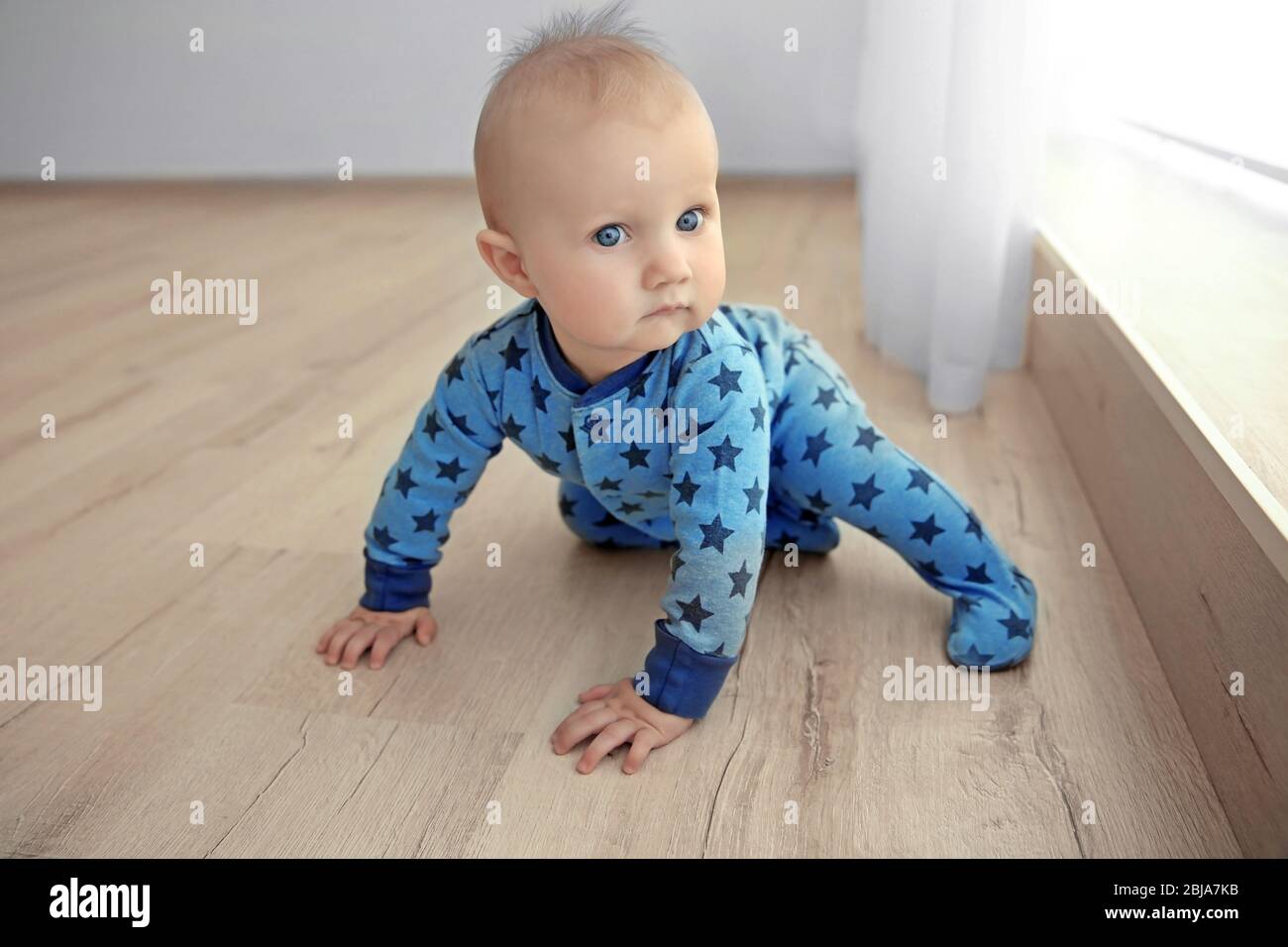 Adorable little baby crawling on wooden floor Stock Photo - Alamy