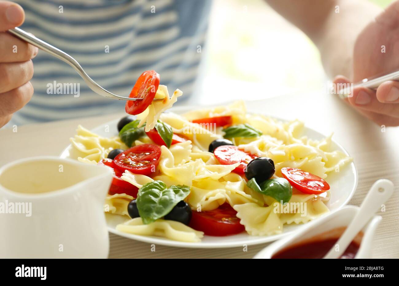 Man eating delicious pasta in restaurant Stock Photo - Alamy
