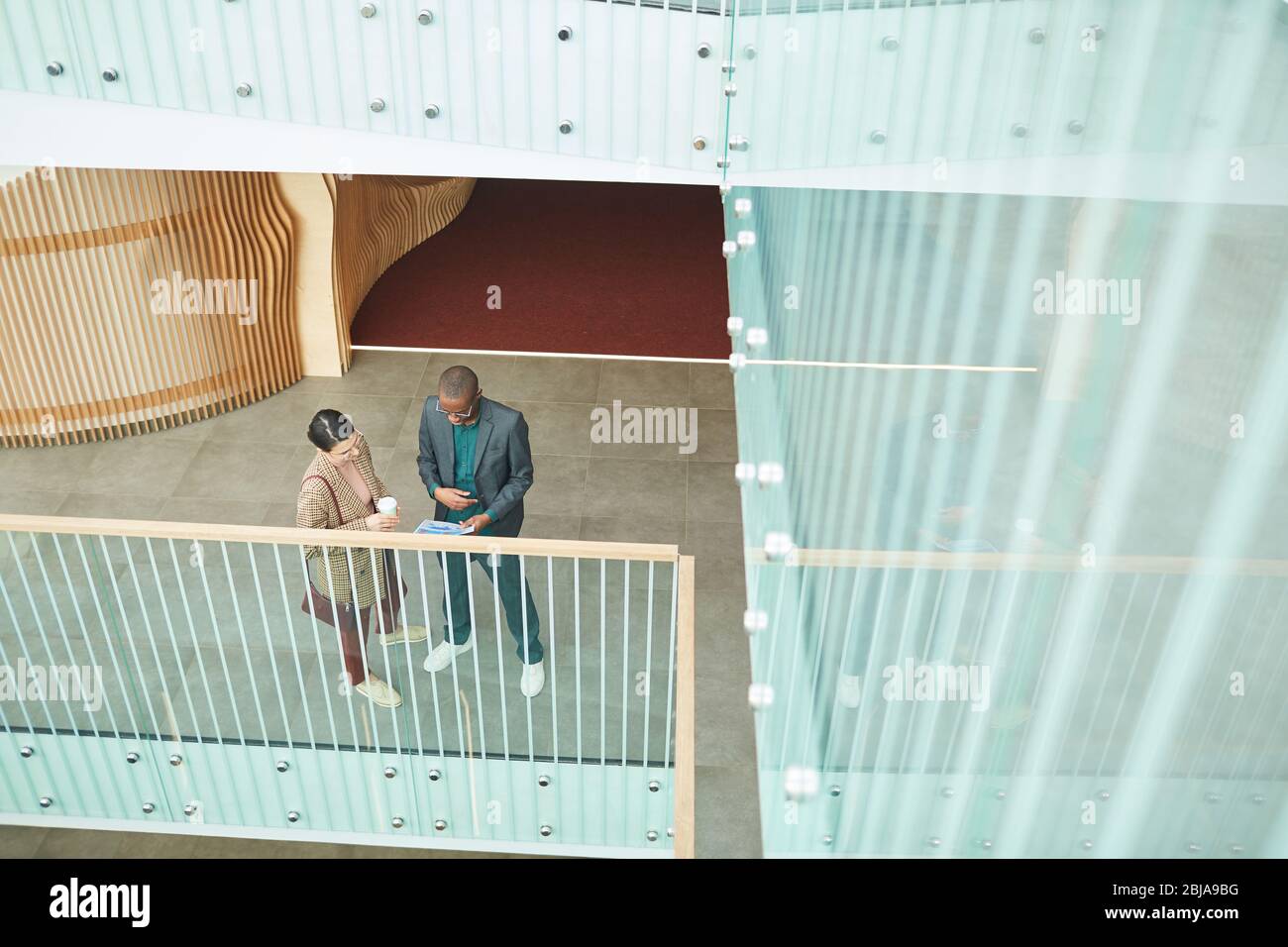 High angle view of two business colleagues discussing about financial ...