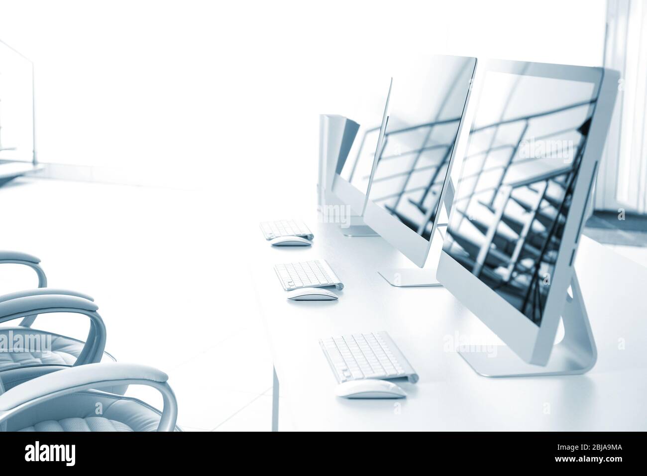 Modern computers on white wooden table in office Stock Photo - Alamy