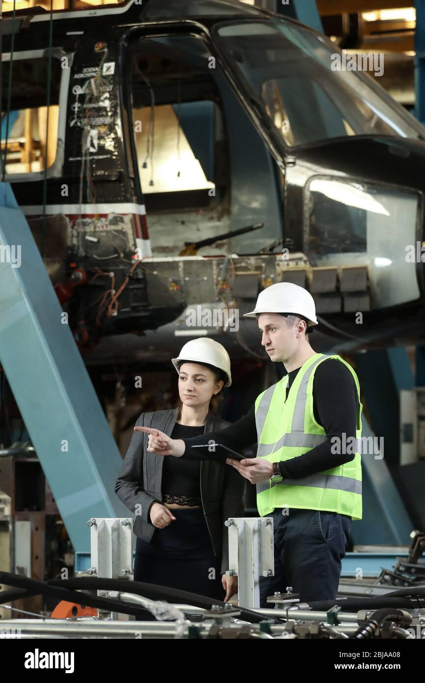 Portrait of a female factory manager in a white hard hat and business ...