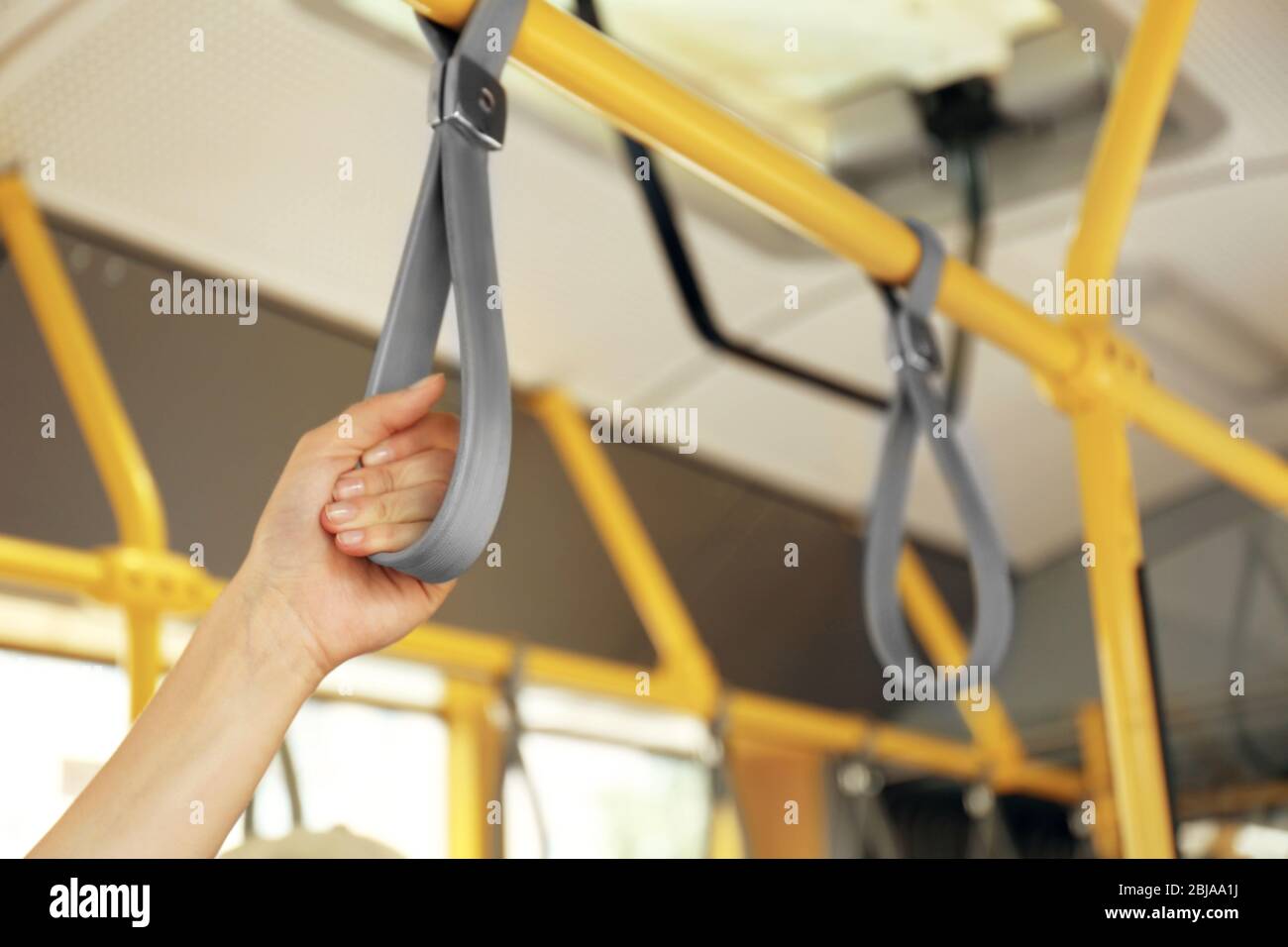 Hand holding handle on the public transport Stock Photo - Alamy