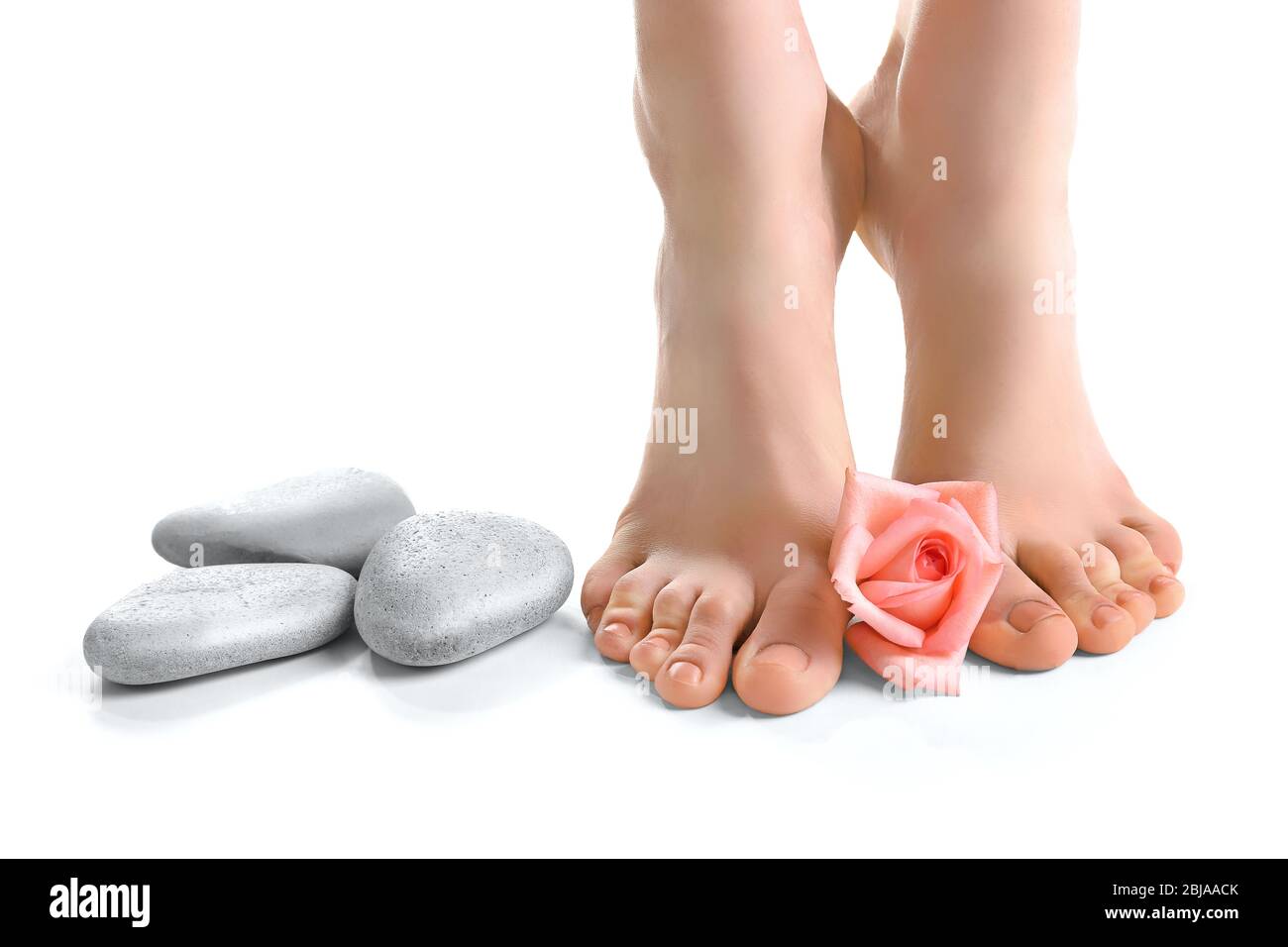 Female feet with spa stones on white background Stock Photo - Alamy