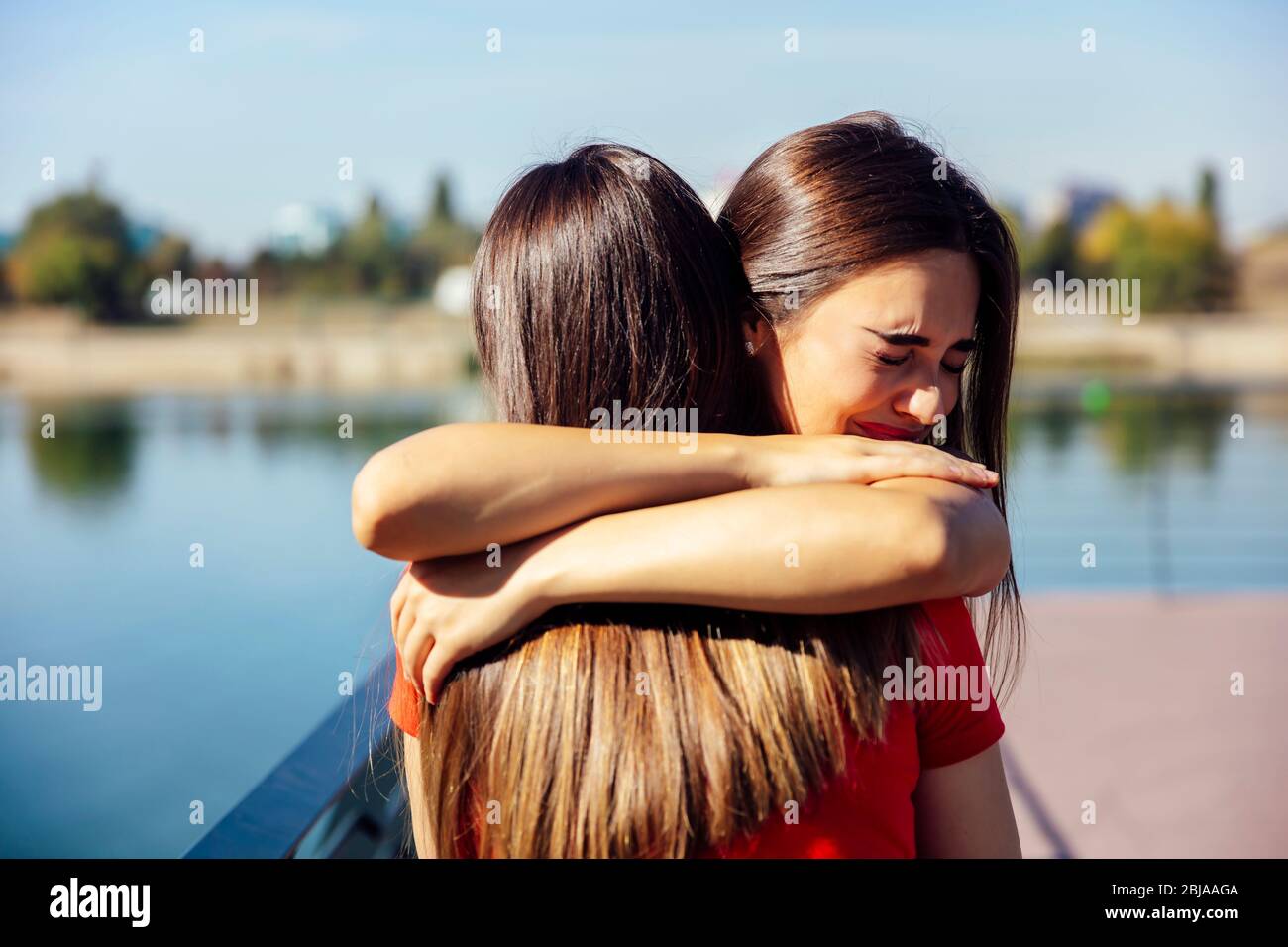 Young woman hugging and supporting her best female friend on the ...