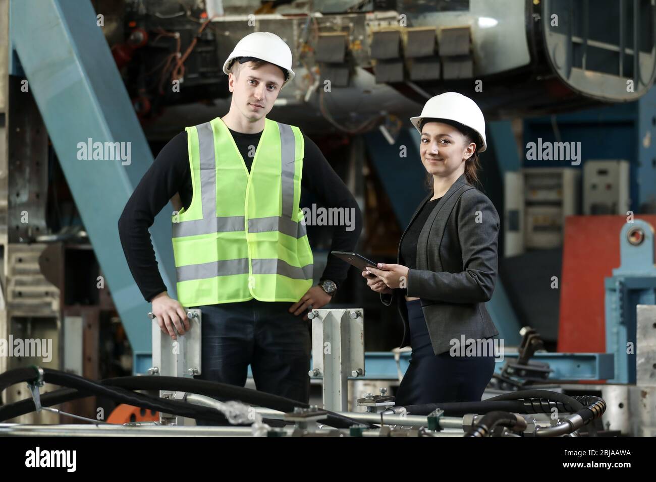 Portrait of a female factory manager in a white hard hat and business ...