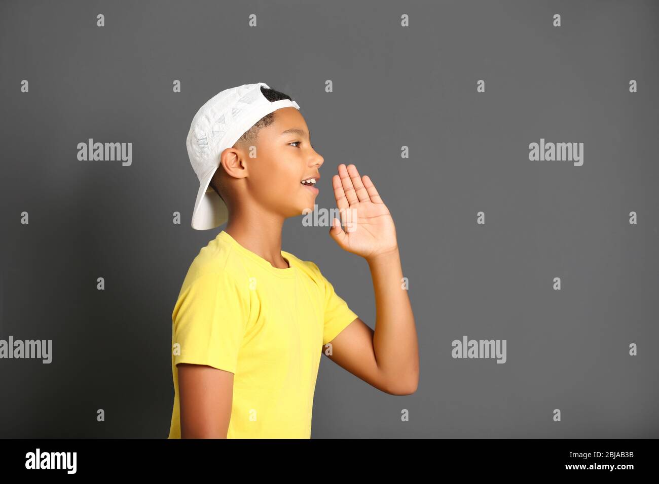 African American boy shouting on grey background Stock Photo - Alamy