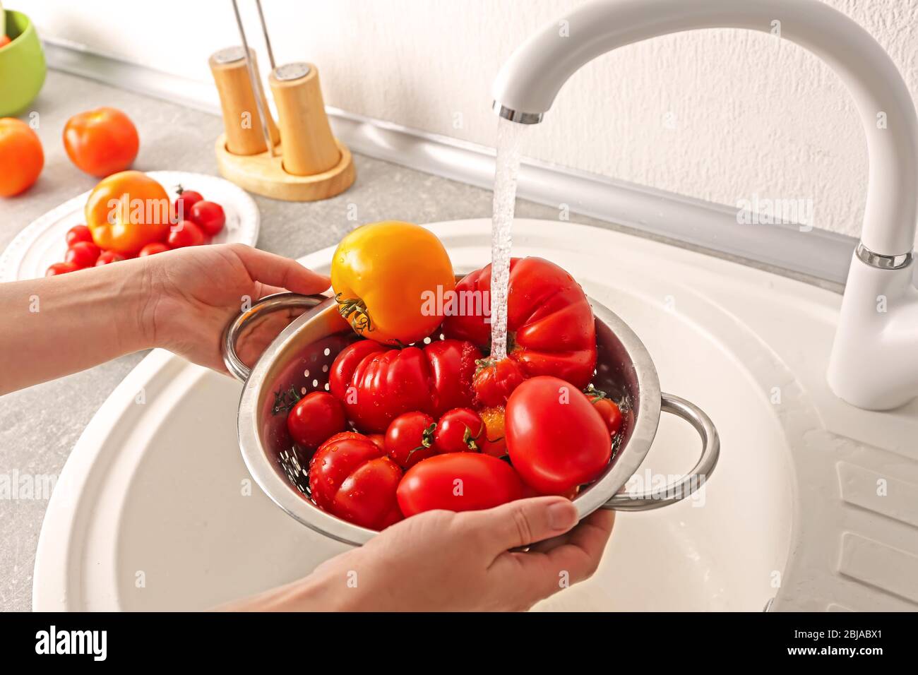 Female hand washing tomatoes hi-res stock photography and images - Alamy