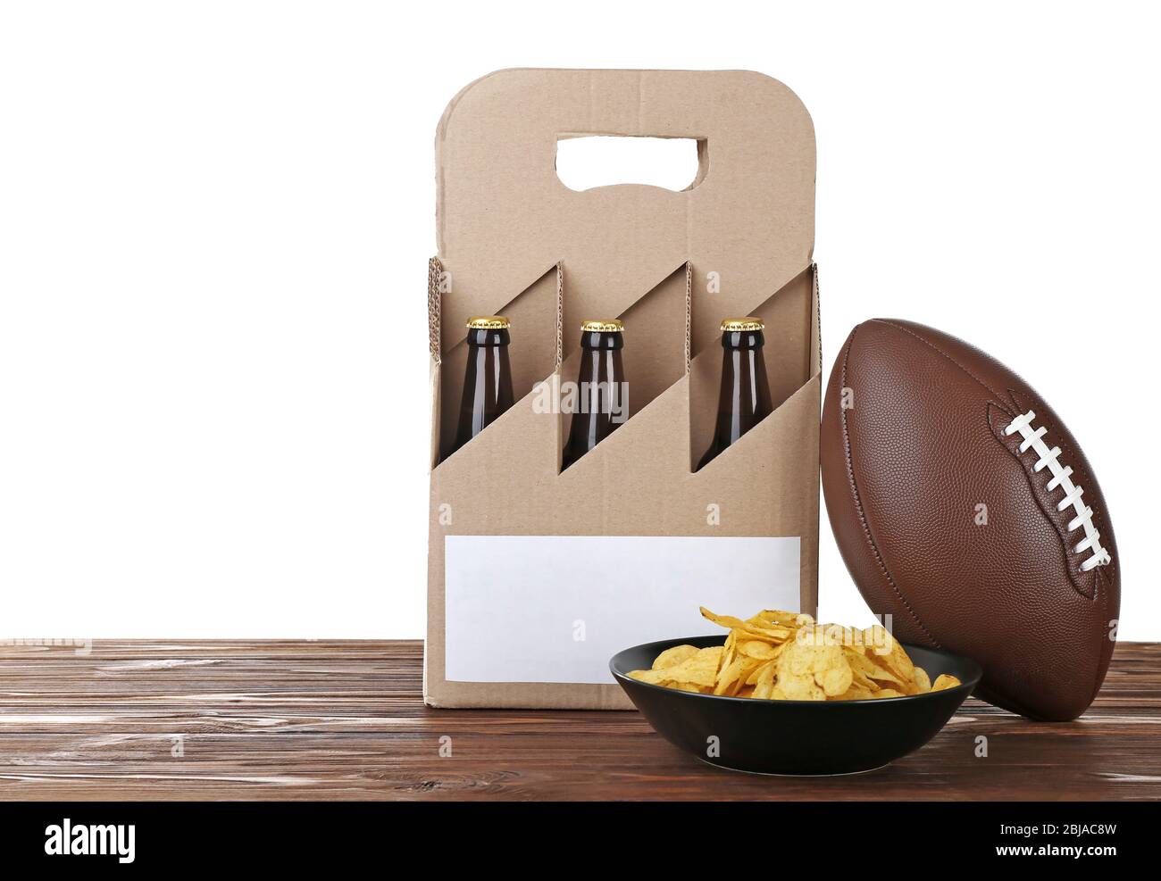 Six pack of beer, ball and snack on wooden table with white background ...