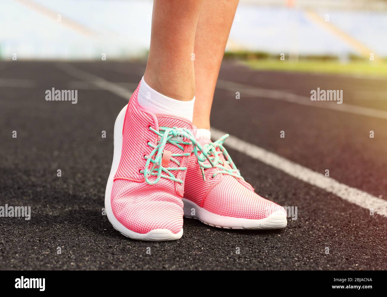 Woman wearing pink sneakers on a running stadium Stock Photo - Alamy