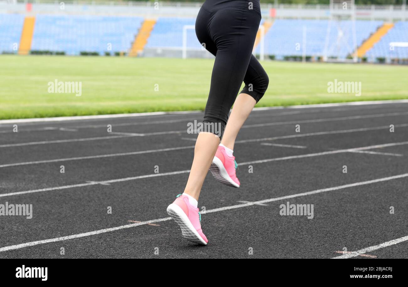 Woman running in pink sneakers on a stadium Stock Photo - Alamy