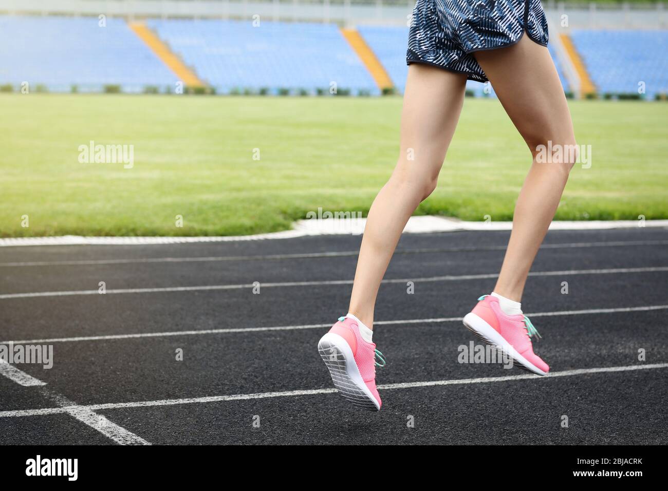 Woman running in pink sneakers on a stadium Stock Photo - Alamy