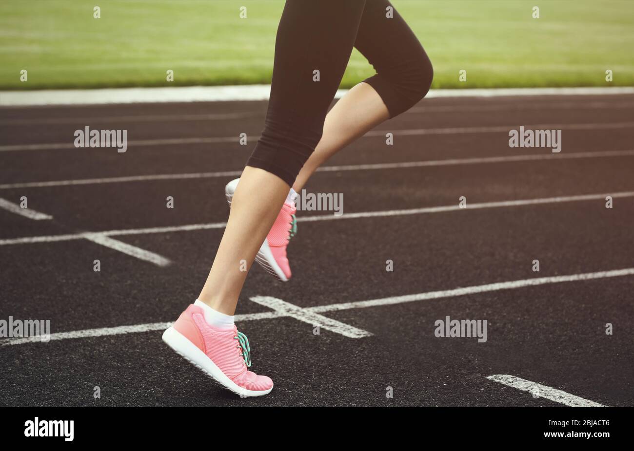 Woman running in pink sneakers on a stadium Stock Photo - Alamy