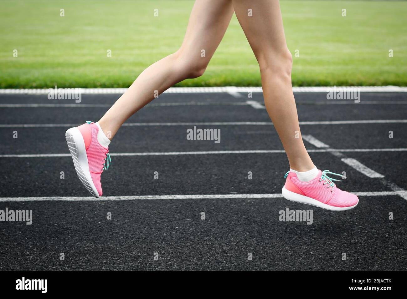 Woman running in pink sneakers on a stadium Stock Photo - Alamy